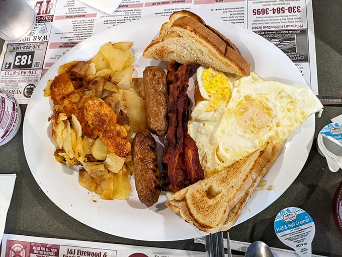 The breakfast plate that launched a thousand productive days – eggs, bacon, sausage, toast, and home fries in perfect harmony.