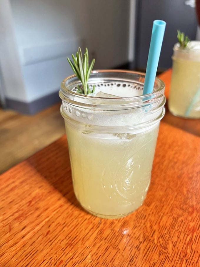 This isn't just a cocktail—it's a refreshing escape in a mason jar, complete with rosemary sprig standing tall like a tiny pine tree.