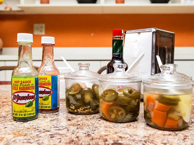 The condiment station – those jars of pickled jalapeños and carrots are the secret weapons that let you customize your heat level with delicious precision.