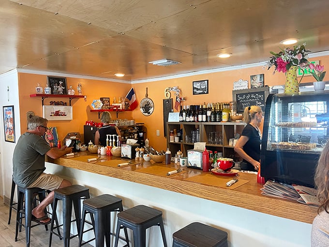 The counter offers front-row seats to the culinary action. That display case in the background holds treasures worth every calorie.