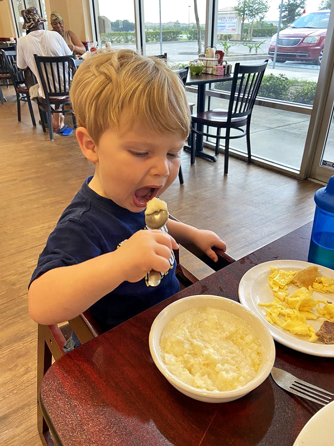 The universal expression of breakfast joy knows no age limit—this young connoisseur demonstrates the proper technique for grits appreciation.