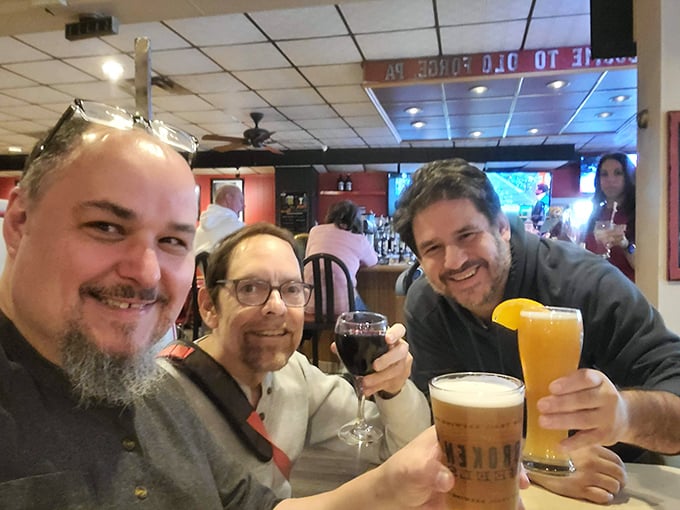 Three friends raising glasses in a toast that says, "We came for the pizza but stayed for the camaraderie"—the universal language of good times.