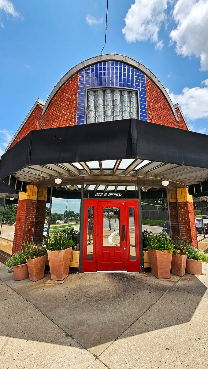 The welcoming entrance, framed by terracotta planters and that distinctive curved facade, promises comfort before you even step inside.