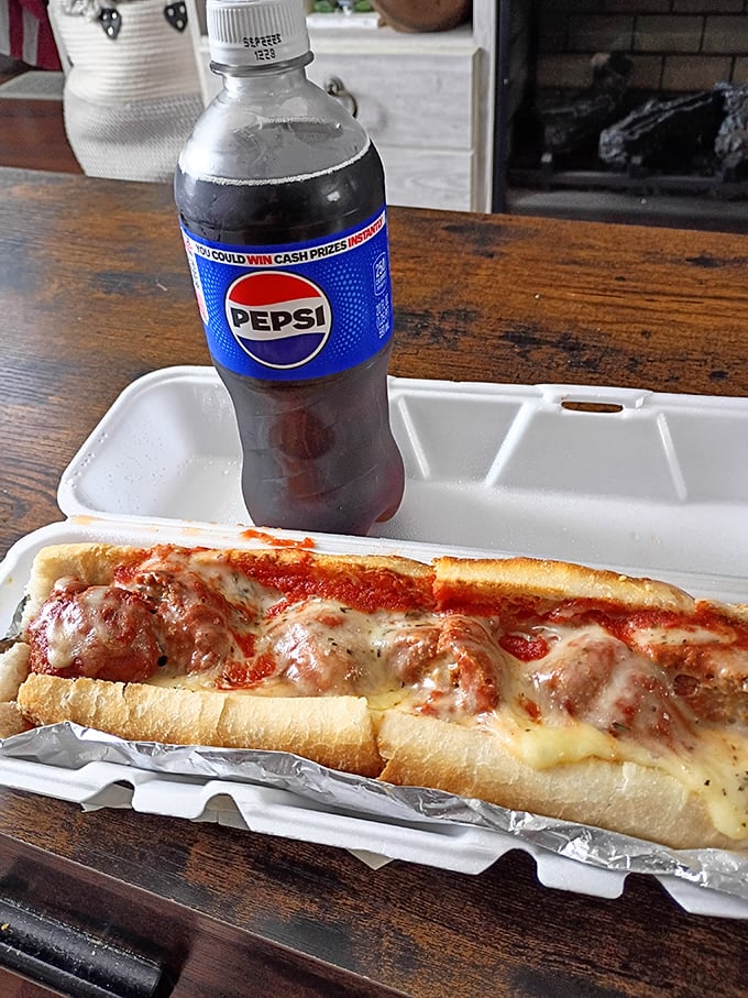 A proper Italian meatball sandwich paired with a cold Pepsi—comfort food that speaks a universal language of satisfaction.