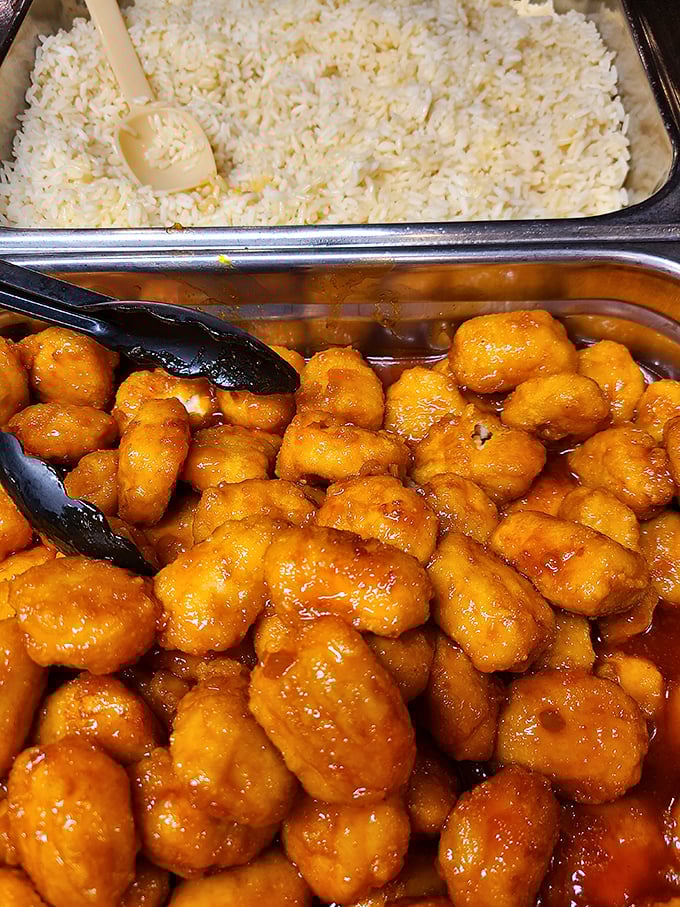 Orange chicken glistening with sweet-tangy sauce sits beside fluffy rice—proof that this steakhouse understands the importance of culinary diversity.