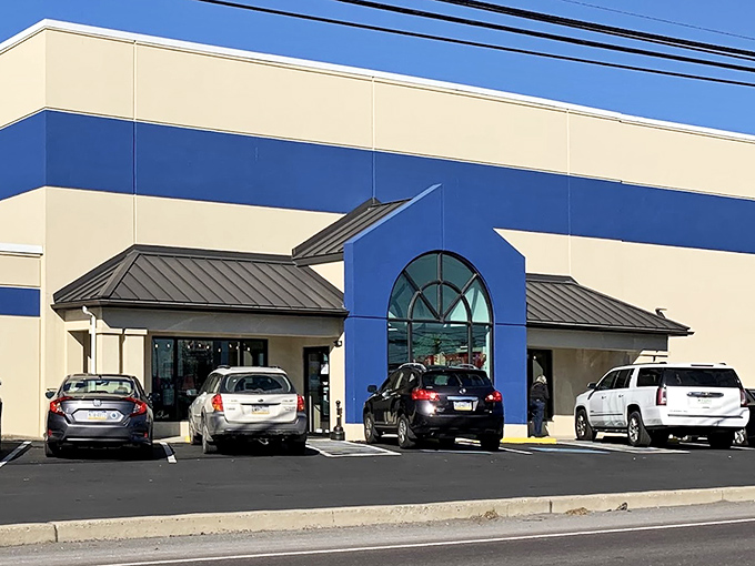 The exterior view reveals the shop's smart blue and beige design, with the curved window detail adding architectural interest to this treasure-hunting destination.