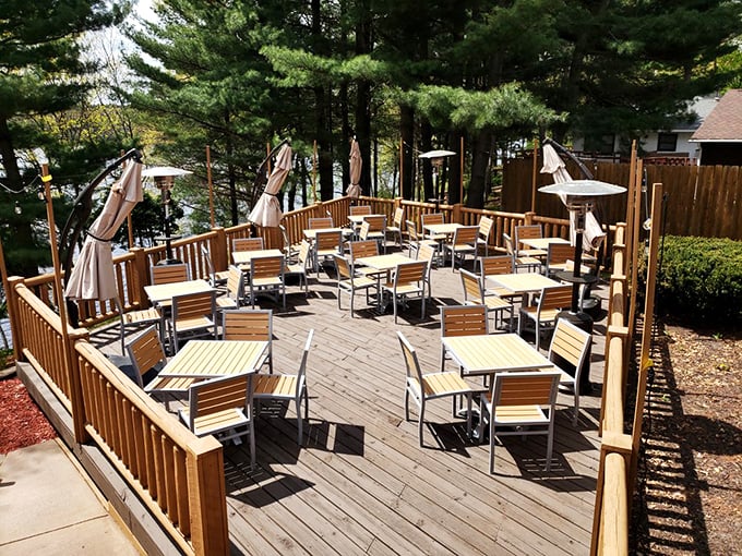 The outdoor deck isn't just seating—it's front-row tickets to nature's best show, with pine trees and lake views included at no extra charge.