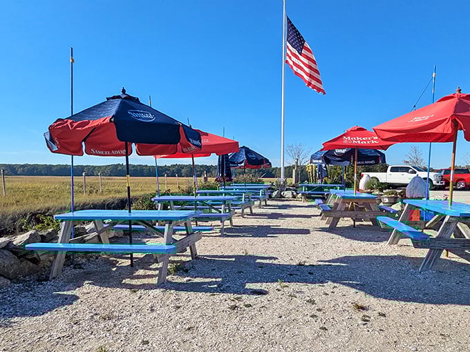 Outdoor picnic tables under red and blue umbrellas offer al fresco dining with an American flag standing proud—seafood just tastes better with a side of fresh air.
