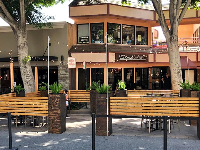 The outdoor seating area offers California dining at its most relaxed – sunshine, wooden benches, and the anticipation of barbecue bliss.