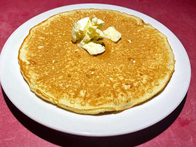 A pancake so perfectly golden it deserves its own sunrise. That butter pat is just melting into breakfast nirvana.