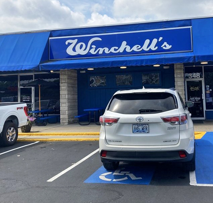 The blue handicap spot perfectly matches Winchell's signature awning—even the parking lot stays on brand in this beloved Lexington institution.