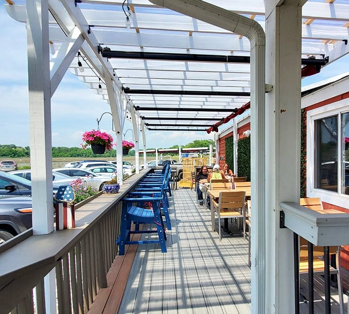 The outdoor patio—where fresh air enhances every bite and those blue chairs practically demand you stay for "just one more" appetizer. 