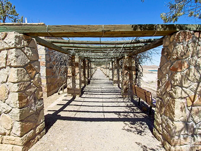 Stone pillars and wooden beams create a desert colonnade. This shaded walkway offers respite from the sun while framing views worth framing.