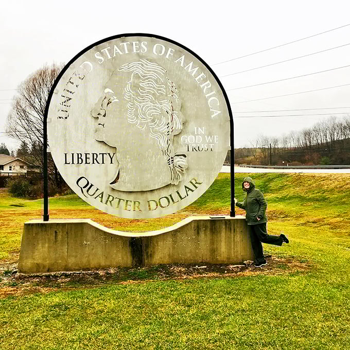 Playful poses with the Giant Quarter have become something of a tradition—this visitor appears to be keeping Washington on his toes.