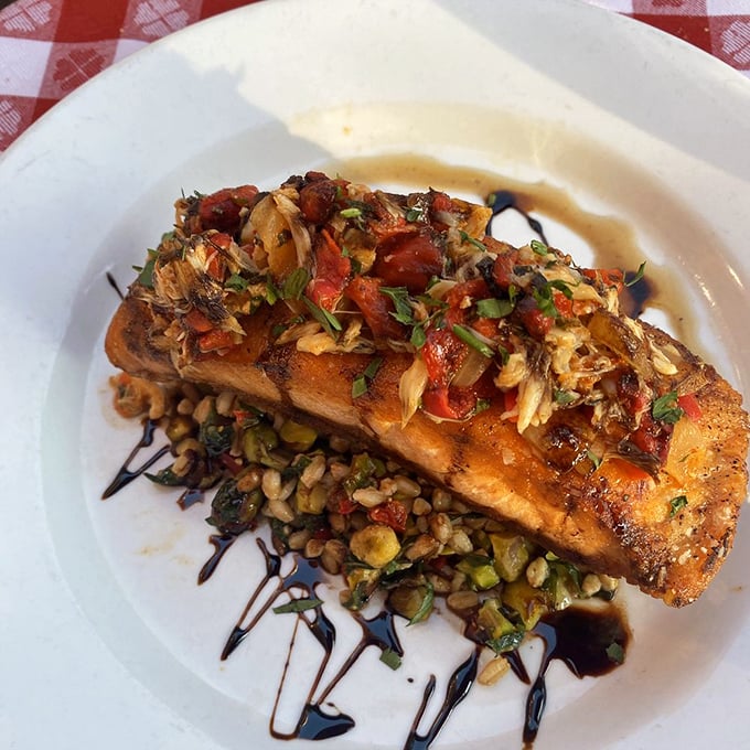 Salmon that's dressed for success—seared to perfection and topped with a confetti of tomatoes and herbs over what appears to be farro.