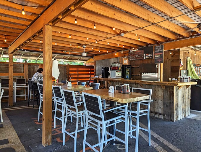 The covered patio area—where fresh air and fresh BBQ create the perfect dining equation. String lights included for ambiance and finding your food.