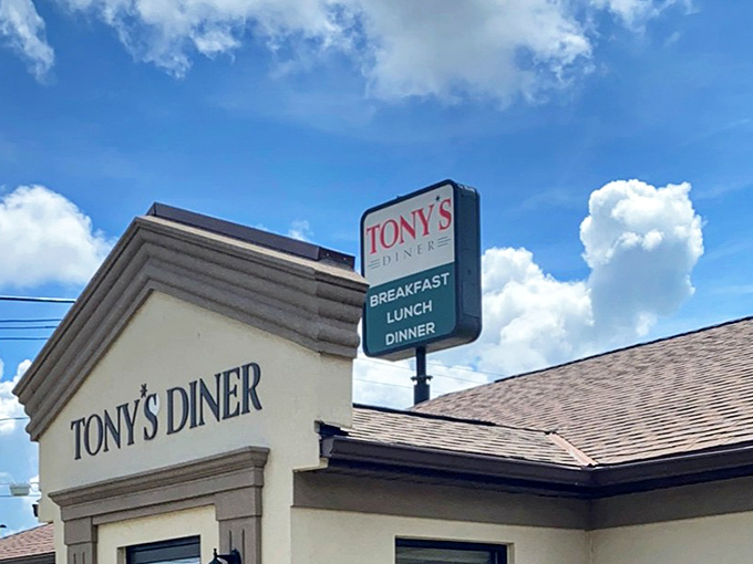 The sign stands tall against the blue sky, like a lighthouse guiding hungry travelers safely to shore. Breakfast, lunch, dinner—the holy trinity of diner offerings.