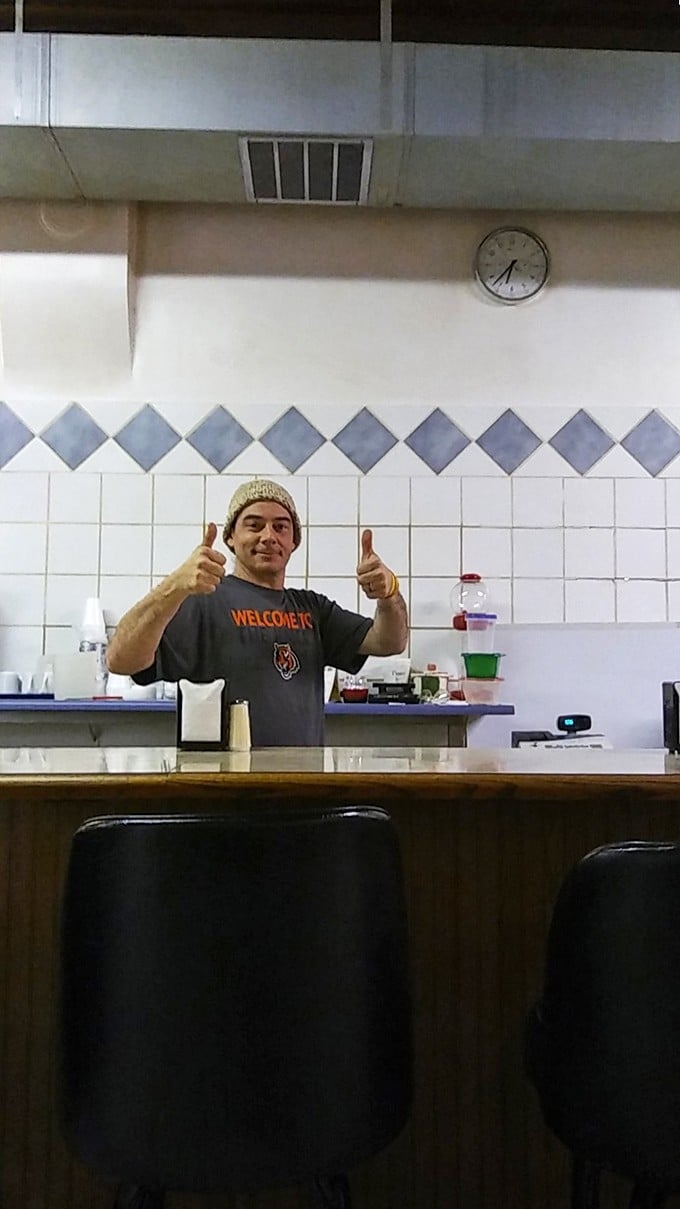 The universal thumbs-up—pizza's international language of approval. When your server looks this happy, you know you've chosen the right place.