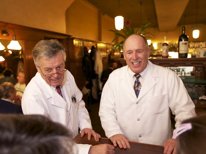 The servers in their crisp white jackets share a laugh – when staff are this happy, you know you're in for exceptional service.