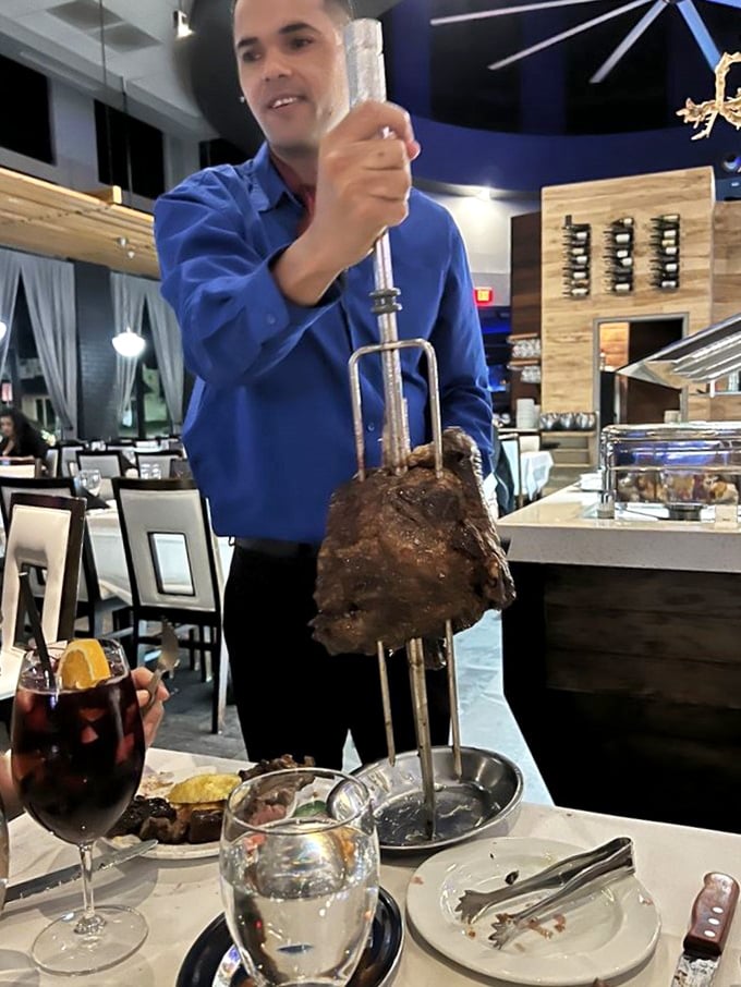 The tableside carving isn't just service—it's theater. That focused expression says, "I take your protein needs very seriously."