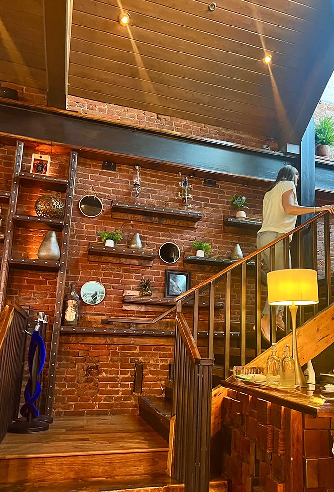 Exposed brick walls adorned with carefully curated shelves create a modern-rustic vibe as you ascend to new levels of dining pleasure.