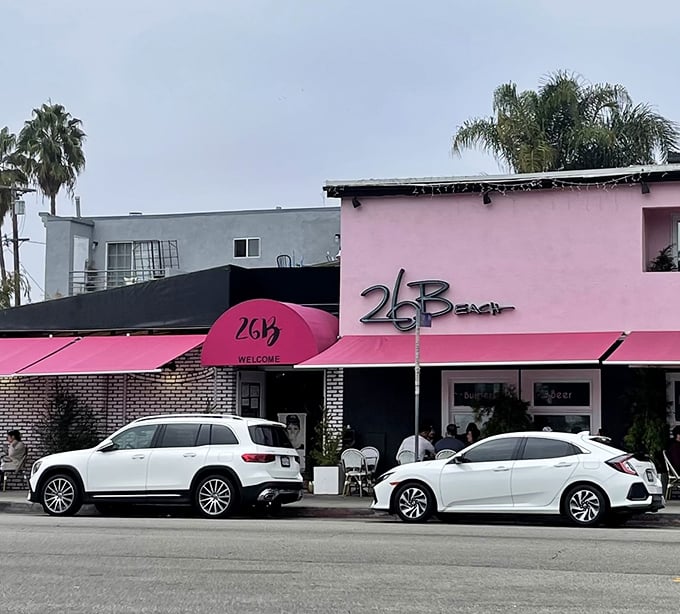 The pink building with its signature awning stands ready for another day of culinary adventures. Cars line up outside—locals know where the good stuff is.