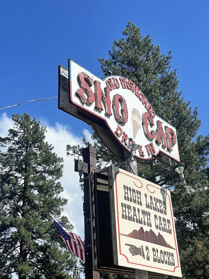 The vintage roadside sign stands as a beacon of hope for hungry travelers—promising salvation in the form of burgers and ice cream.