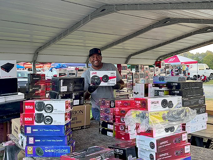 A vendor's pride shines brighter than his merchandise—that smile says he knows exactly what audio treasures he's offering.