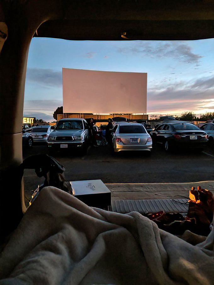 The perfect drive-in setup: blankets, twilight sky, and an unobstructed view of the screen. Cinema as it was meant to be experienced.