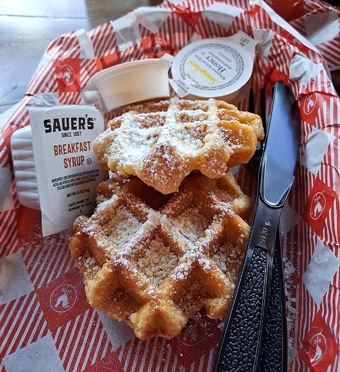 These aren't just waffles—they're golden, crispy life rafts in a sea of spice, dusted with powdered sugar and ready for their maple baptism.
