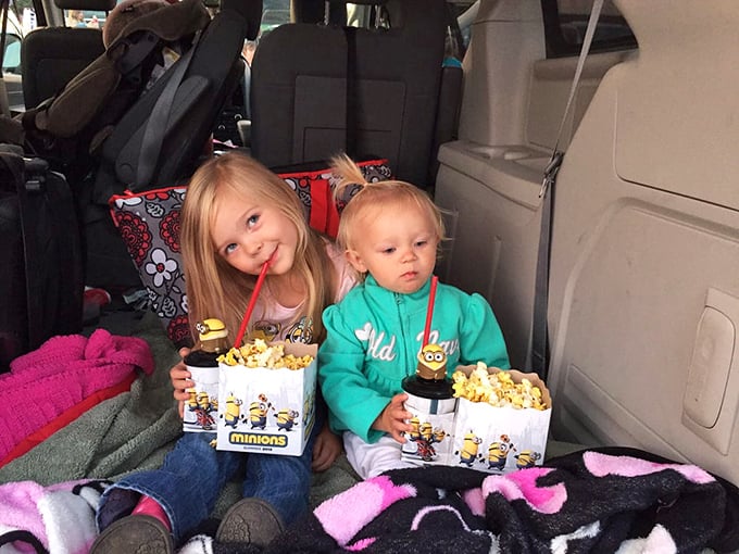 The backseat becomes prime real estate on movie night, where kids clutch popcorn buckets bigger than their heads.