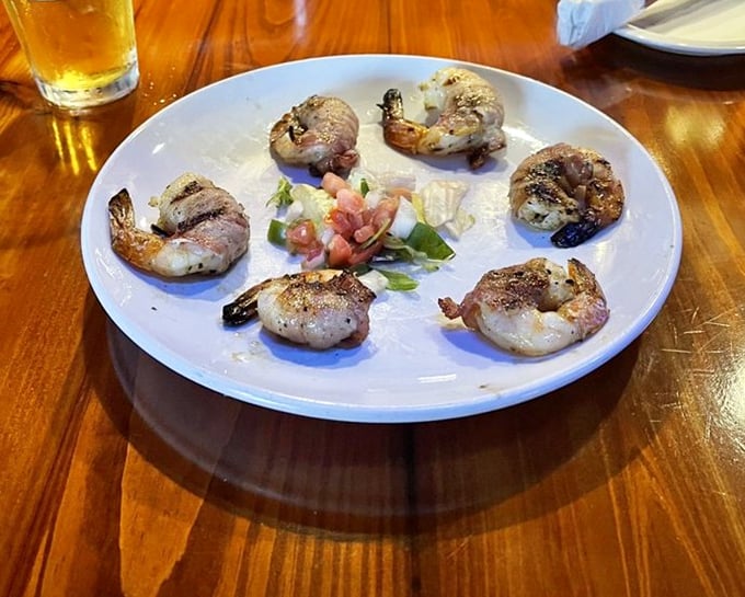 These bacon-wrapped shrimp aren't just appetizers—they're little ambassadors of land-meets-sea perfection that disappear faster than Kansas rain.