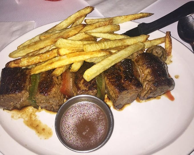 The Beef Brochette arrives like a savory still life—meat, peppers, and fries arranged in a composition that's both art and dinner.