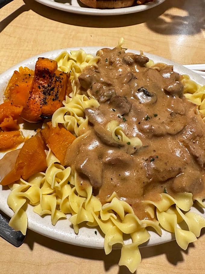 Beef stroganoff that means business—tender meat and mushrooms in a rich sauce, blanketing egg noodles with buttery squash standing guard on the side.