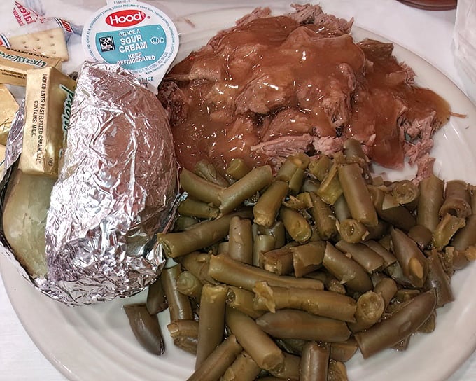 Brisket so tender it surrenders to your fork, green beans that taste like summer, and a baked potato in foil—the holy trinity of heartland dining.