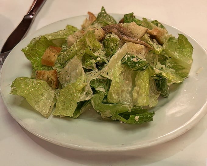 The Caesar salad – that obligatory nod to greenery that somehow manages to be indulgent anyway, with its creamy dressing and crisp romaine.