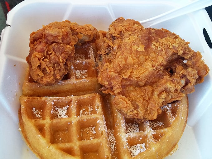 The star of the show: golden chicken perched atop a powdered waffle. This isn't just breakfast meets dinner—it's a flavor marriage made in heaven.