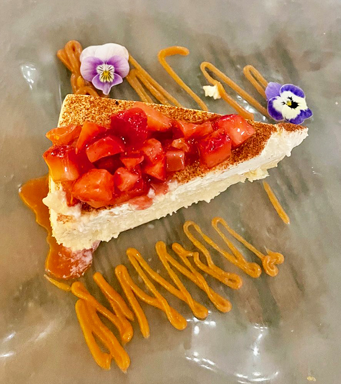 Cheesecake living its best life with berry topping and edible flowers—dessert that's dressed better than most people at the restaurant.