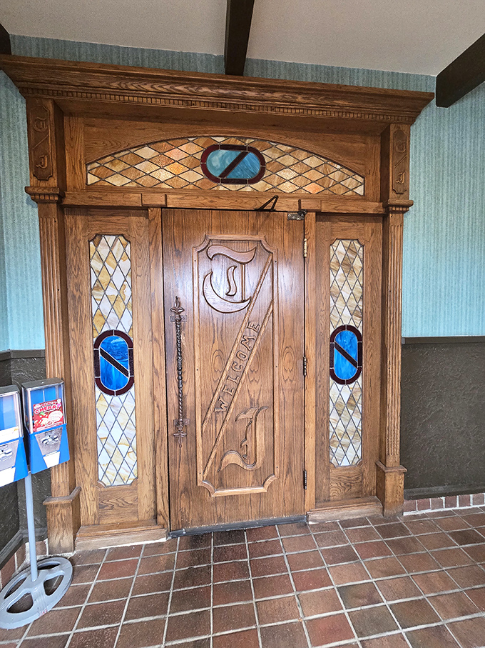 An entrance door worthy of a medieval castle or speakeasy, complete with stained glass and ornate woodwork—the perfect portal to old-school dining excellence.