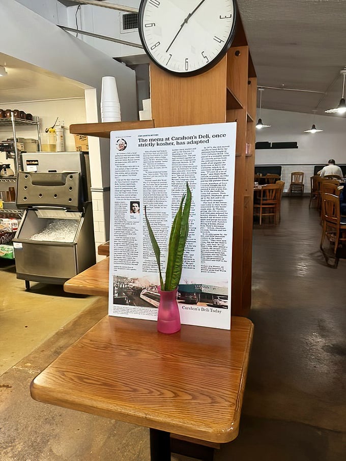 A framed article stands sentinel near a simple plant—history and life side by side, reminding us that great food traditions endure for good reason.