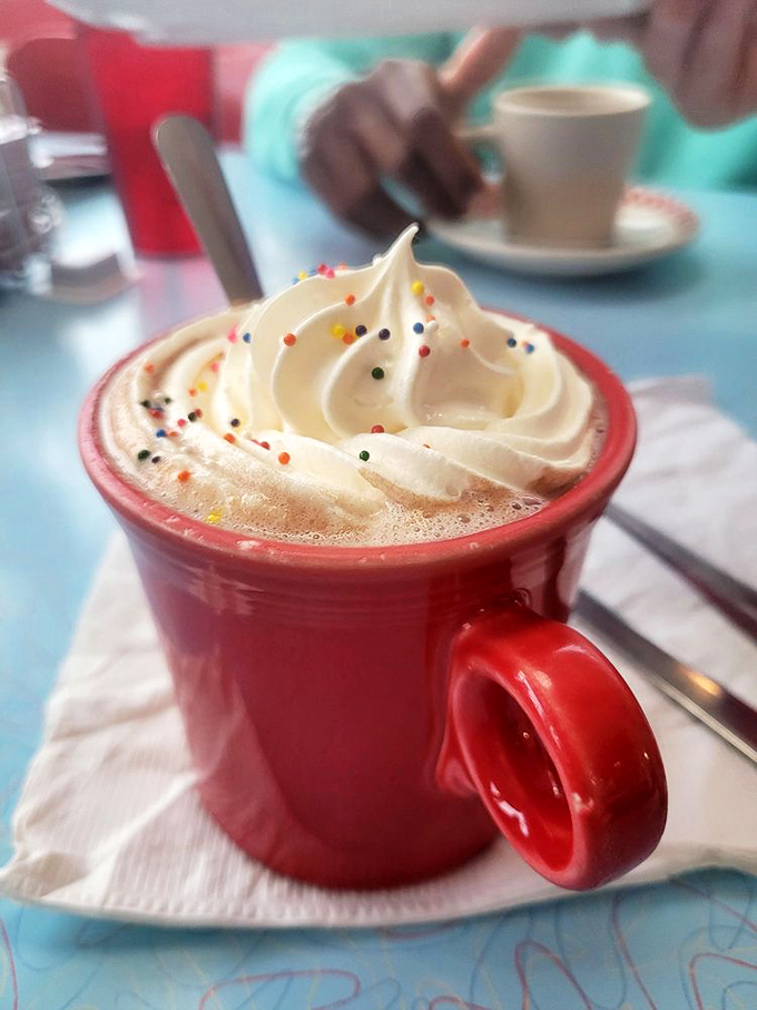 Hot chocolate that wears whipped cream like a jaunty beret. Those sprinkles aren't decoration—they're confetti for your taste buds.