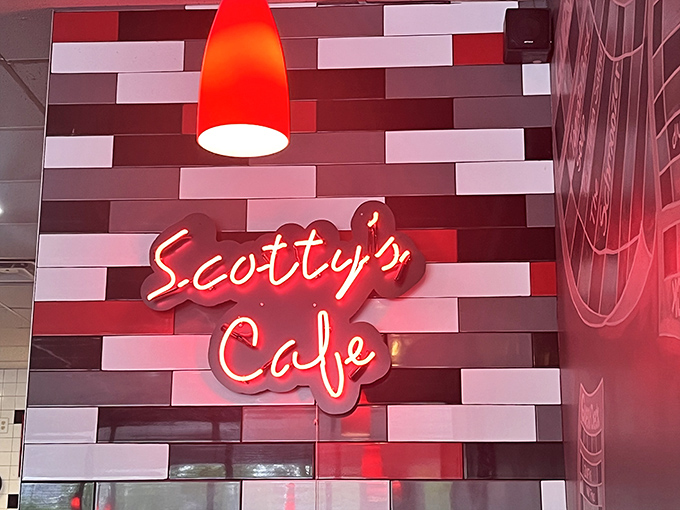 The signature neon "Scotty's Café" sign against colorful subway tiles serves as a beacon of hope for the hungry and a promise of satisfaction to come.