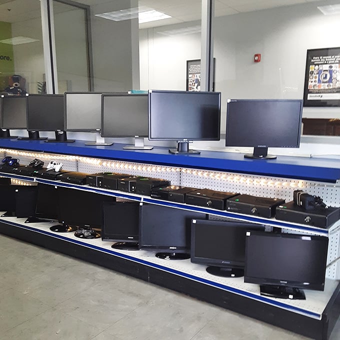 15. The monitor lineup stands at attention like electronic soldiers, each screen blank but full of potential, waiting to display someone's future spreadsheets or family photos.
