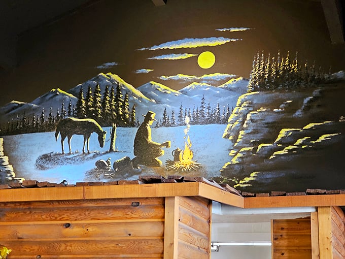 The cowboy mural watches over diners like a painted guardian. Under that Arizona moon, even painted campfires feel warm.