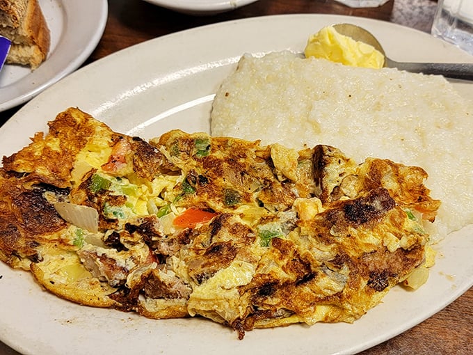 This omelet has more fillings than your average novel has plot twists. Paired with creamy grits—a breakfast that demands to be savored.