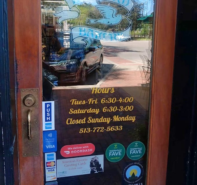 Business hours etched on glass—the fine print of happiness that smart visitors photograph immediately to avoid disappointment later.