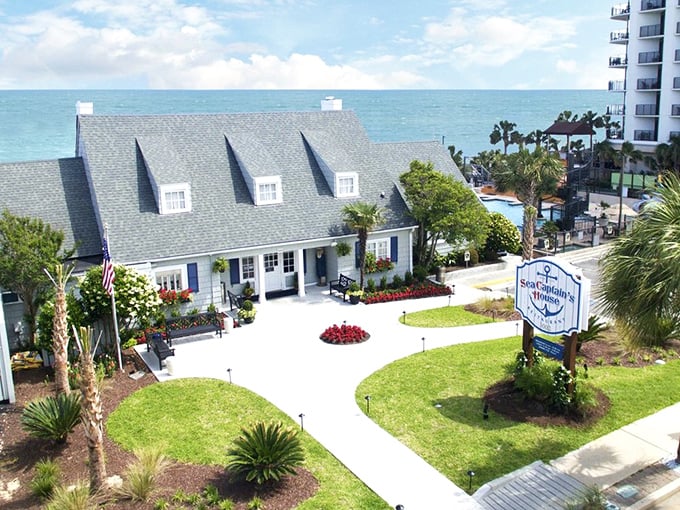 A cottage by the sea that looks like it was plucked from a storybook. The manicured grounds and white walkway welcome you to seafood paradise.