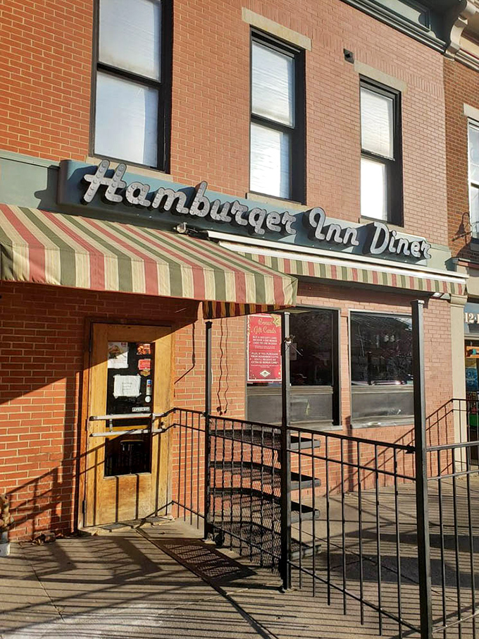 That striped awning isn't just shade – it's a portal to simpler times when a good burger and conversation were all you needed.
