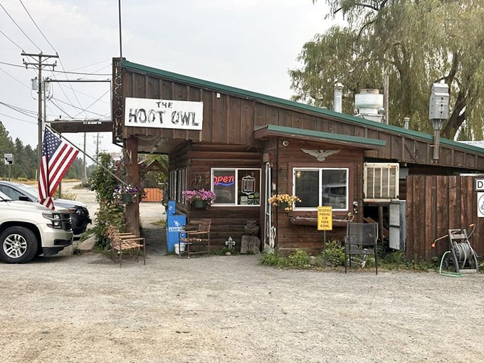 The American flag flutters beside the rustic wooden exterior, flower baskets adding touches of color—a quintessential small-town Idaho breakfast spot that delivers big flavors.