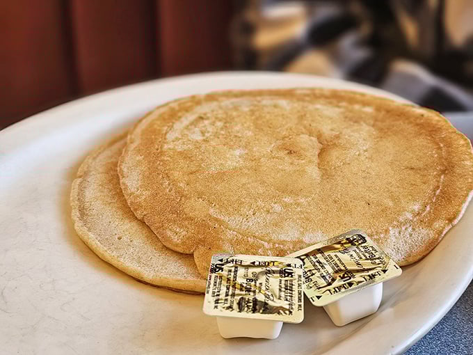 Pancakes so perfectly golden they deserve their own Instagram account—the butter melting into those fluffy ridges tells the whole story.